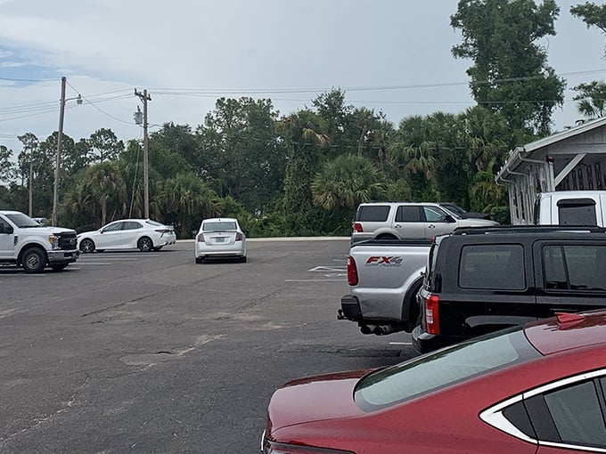 A parking lot surrounded by palm trees and pines – nature's way of saying "you're still in Florida, but you're about to eat something special."