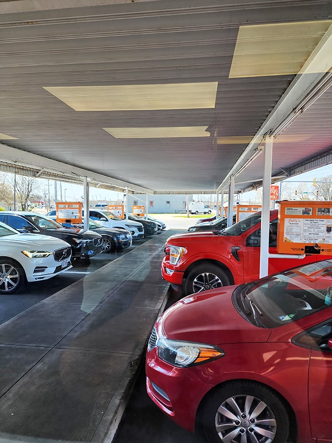 The covered parking area &ndash; where cars gather like hungry pilgrims at a shrine to American comfort food. Every space tells a story.