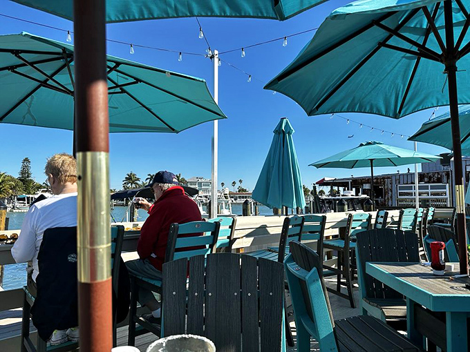 Waterfront patio dining where Gulf breezes and umbrella shade create the perfect setting for a leisurely seafood feast.