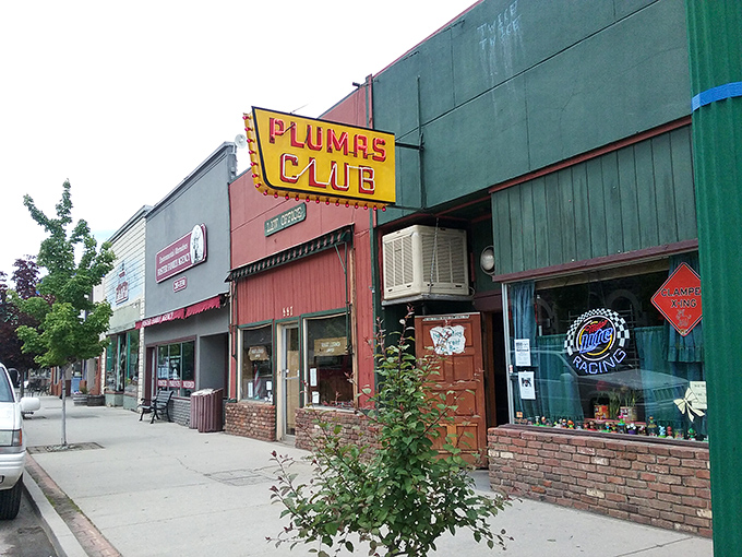 The Plumas Club neon sign glows with small-town promise: cold drinks, warm conversation, and zero chance of a velvet rope or cover charge.
