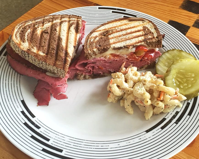 A sandwich with perfect grill marks and a personality to match. That pickle and pasta salad aren't mere sides&mdash;they're supporting actors in a delicious drama.