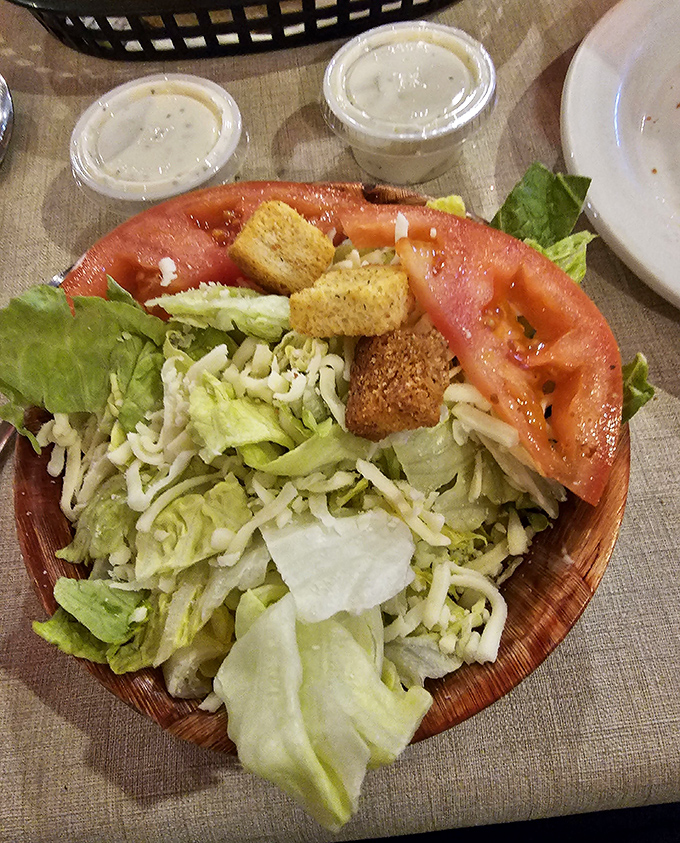 A salad that knows its role—bringing fresh, crisp contrast to all that glorious pasta. Those tomato slices are practically posing for their portrait.