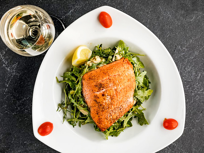 This salmon appears to have had a perfect life, culminating in being expertly prepared and served atop a bed of peppery arugula.