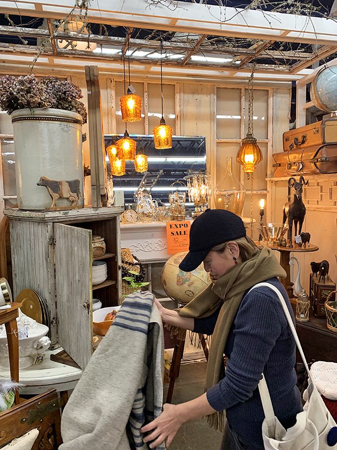 Treasure hunting requires focus and determination. This shopper examines textiles with the concentration of a detective at a crime scene.
