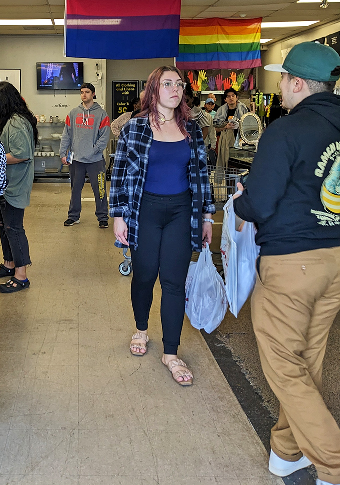Shoppers navigate the treasure-filled aisles beneath pride flags, bags in hand, already victorious in the hunt for affordable style.