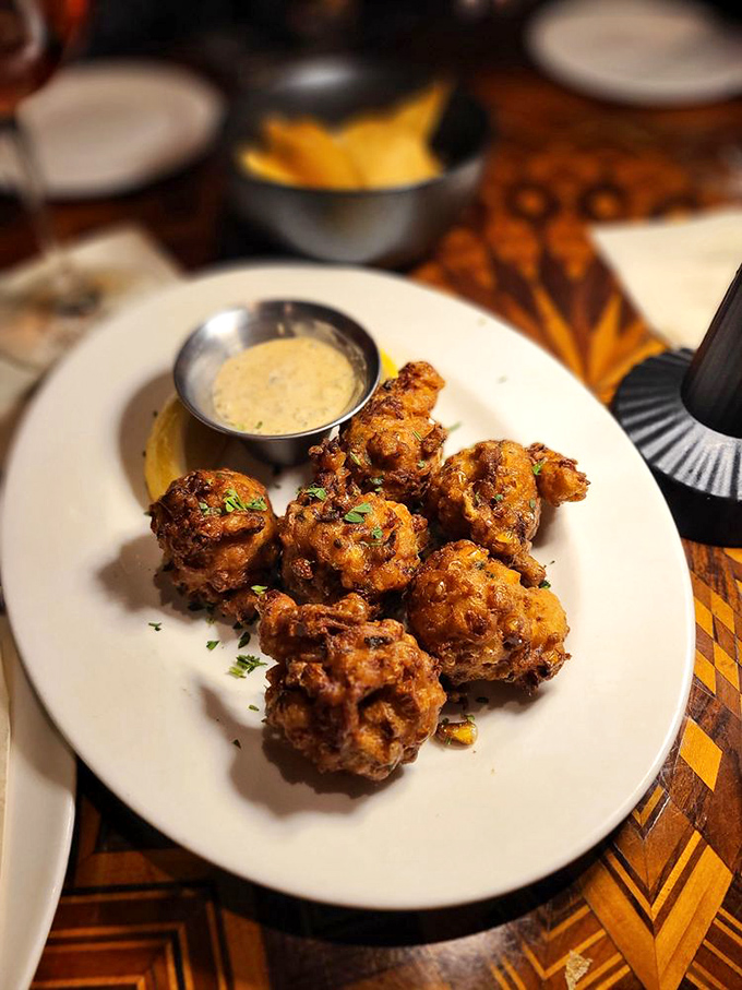 These golden fritters aren't just appetizers; they're crispy preludes to the main event, served with a sauce that demands to be scraped clean.