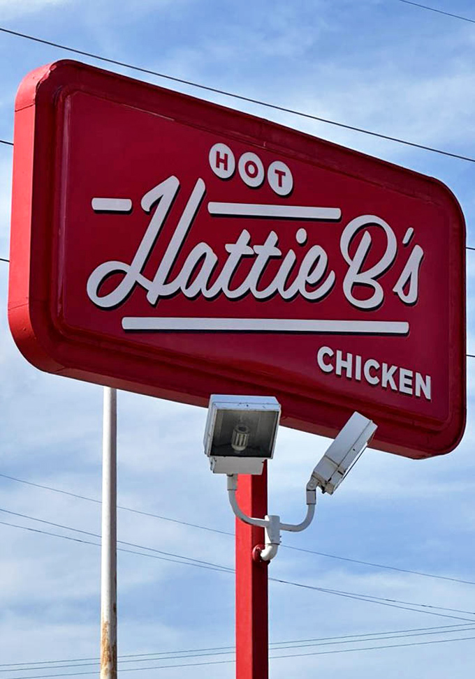 That red sign against the blue Tennessee sky isn't just a logo—it's a beacon of hope for hungry travelers seeking Nashville's spicy treasure.