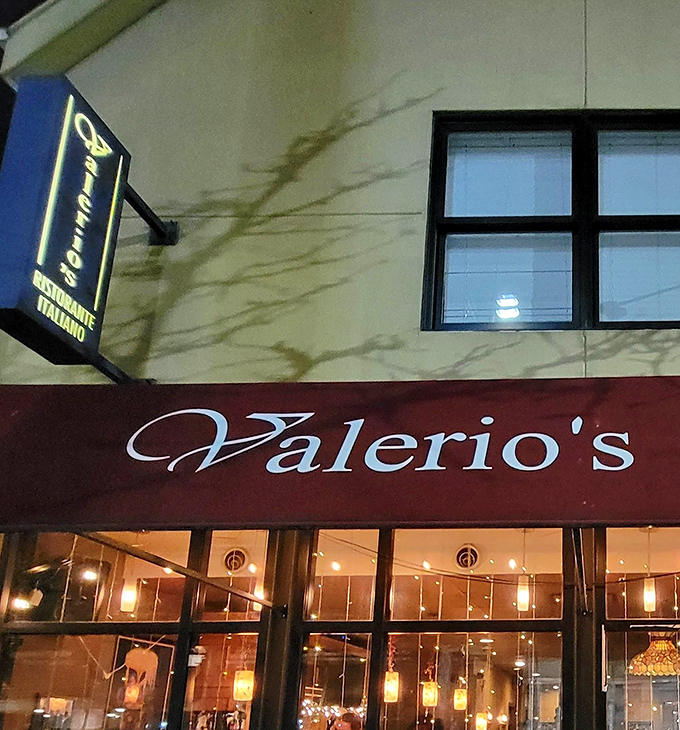 The illuminated Valerio's sign serves as a beacon for those in the know—a glowing promise of culinary excellence waiting just beyond the threshold.