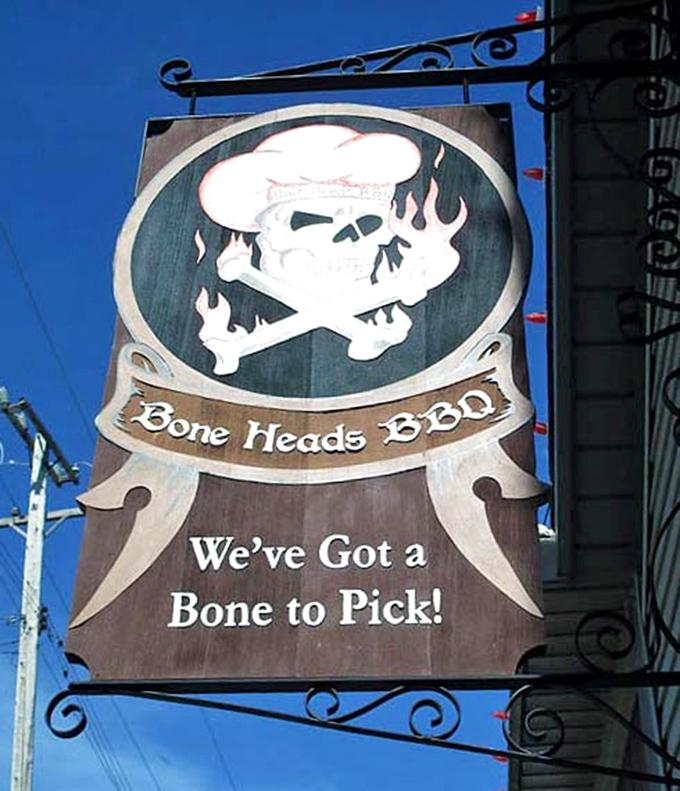 "We've Got a Bone to Pick!" proclaims the playful sign, featuring a chef's skull that suggests they're dead serious about barbecue.