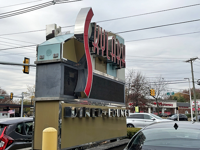 The roadside sign stands as a monument to neon nostalgia, promising weary travelers that yes, exceptional food awaits just beyond those doors.