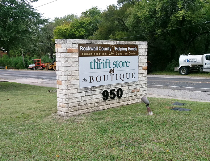 The stone marquee stands as a beacon for bargain hunters, announcing this charitable shopping paradise to passing traffic on Rockwall's busy streets.