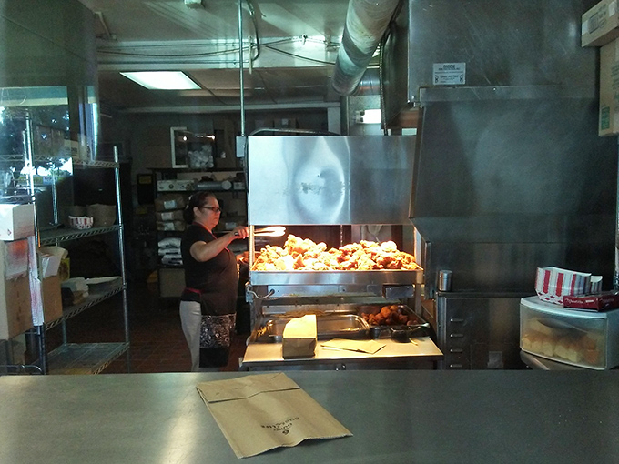 Dedicated hands at work in the chicken kingdom. Years of experience transform raw ingredients into neighborhood legend.