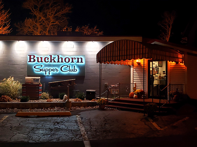 As night falls, the illuminated Buckhorn sign becomes a lighthouse for hungry travelers, promising warmth and satisfaction just steps away.