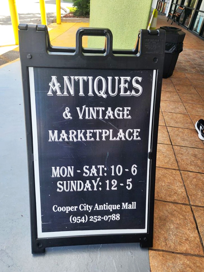 The sidewalk sign announces business hours with vintage flair &ndash; an invitation to step away from the digital world and into tactile nostalgia.