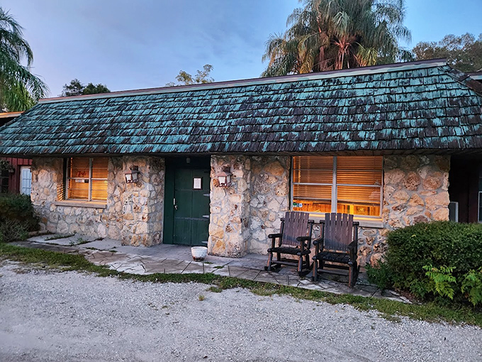 As dusk approaches, the stone facade and weathered green roof take on a magical quality, promising comfort and satisfaction within.