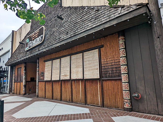 The storefront stands like a thatched-roof sentinel on Brand Boulevard – a mid-century promise of tropical escape and carnivorous delights.