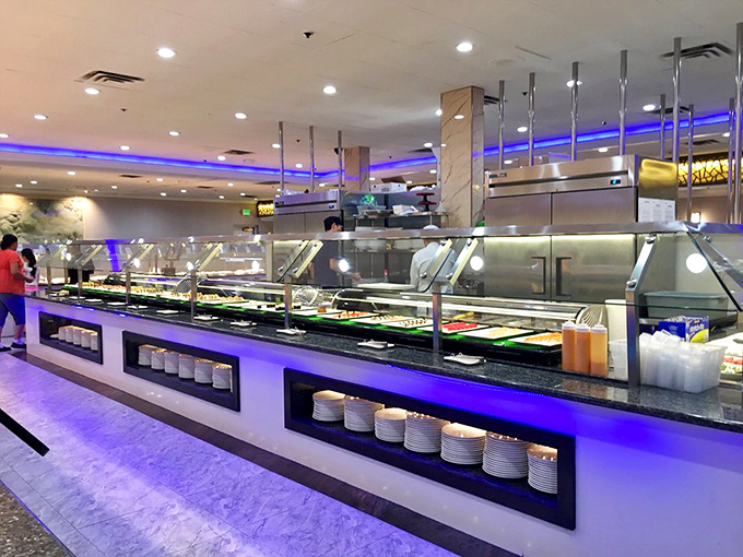 Plates stacked with military precision, awaiting their moment to serve. The buffet line stands ready for the next wave of diners.