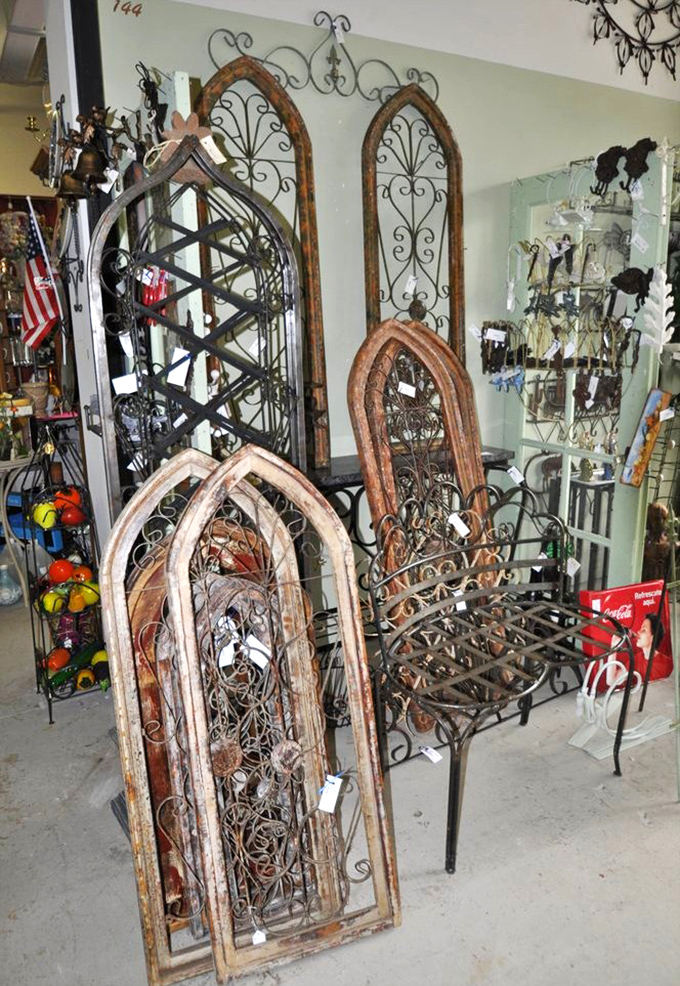 Architectural salvage becomes functional art. These vintage window frames and ironwork pieces bring character that no big-box store can match.