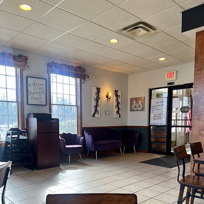 A cozy waiting area with purple accents and a "Welcome to our Beautiful Chaos" sign that somehow makes waiting for your food part of the experience.