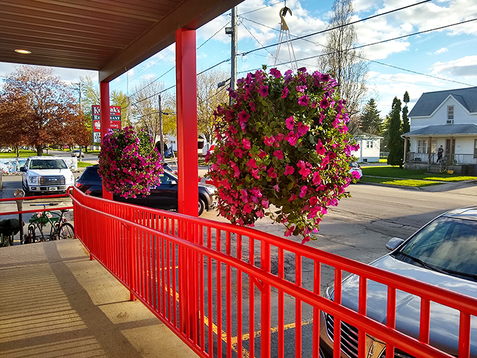 Hanging flower baskets add splashes of color along the red railing, like nature's own welcome committee for hungry visitors.