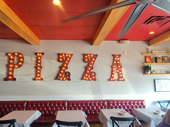 Those illuminated PIZZA letters aren't just decor&mdash;they're a promise. The red banquette seating below stands ready for those serious about their Italian feast.