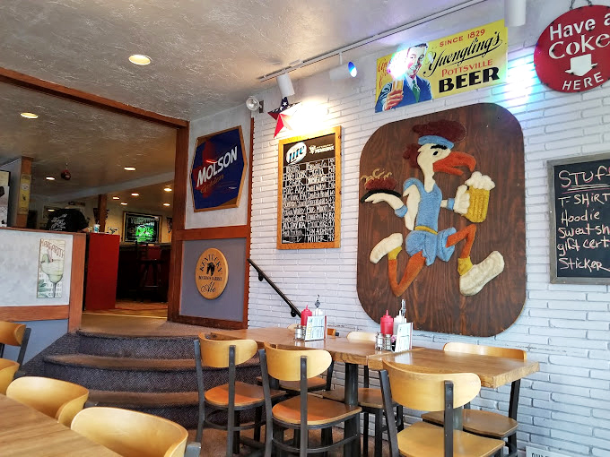 That cartoon bird mascot has seen things—mainly people falling in love with wings. The white brick wall creates the perfect canvas for beer signs and menus.