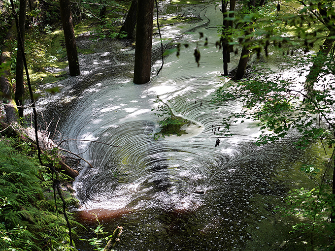 Water cascades down limestone walls in hypnotic patterns. This natural infinity pool has been swirling for millennia, no maintenance crew required.