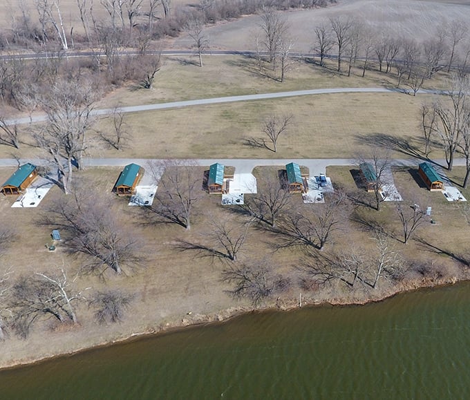 An aerial view reveals the perfect positioning of lakeside cabins, each offering its own slice of waterfront tranquility.