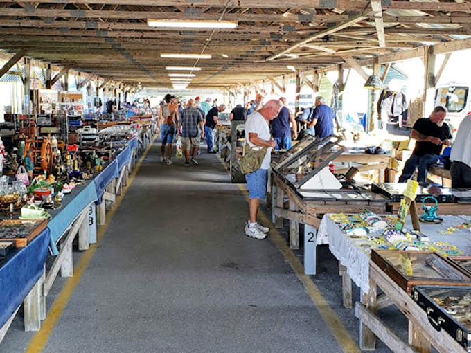 The market's main thoroughfare: a highway of possibilities. Shoppers scan tables with the focus of detectives searching for that one perfect clue.