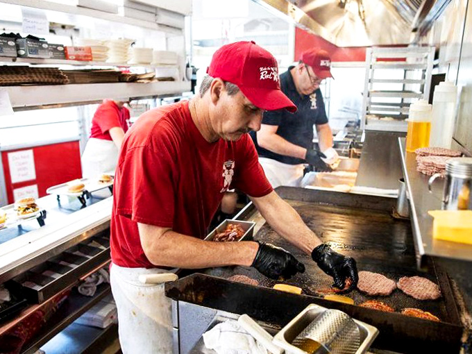 The grill masters of Red Rabbit perform their sizzling symphony. That focused concentration? It's the face of someone who knows burger perfection isn't accidental.