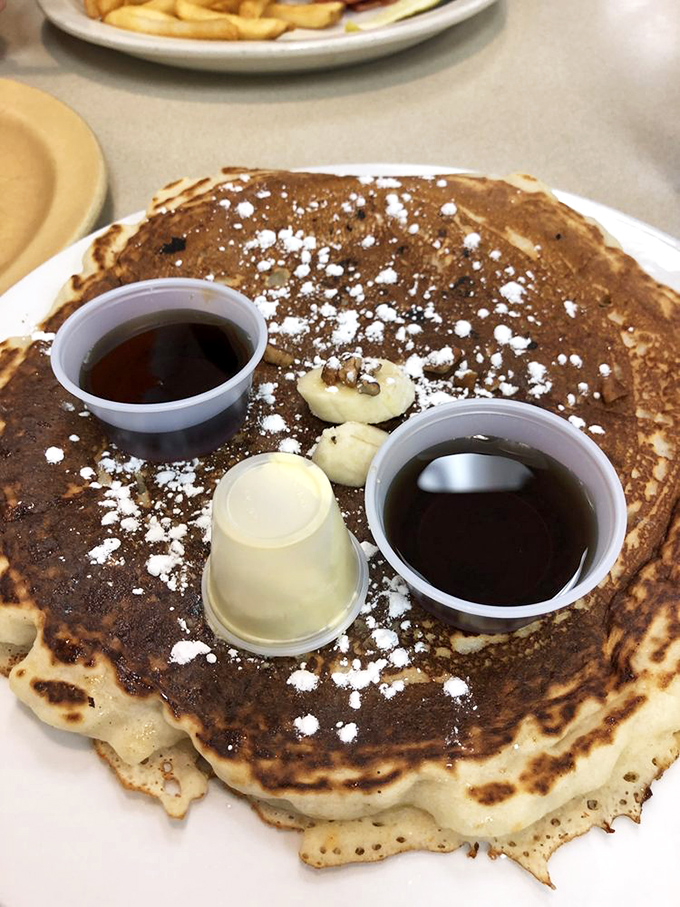 This pancake has achieved celebrity status with its perfect golden hue, powdered sugar dusting, and syrup waiting in the wings.