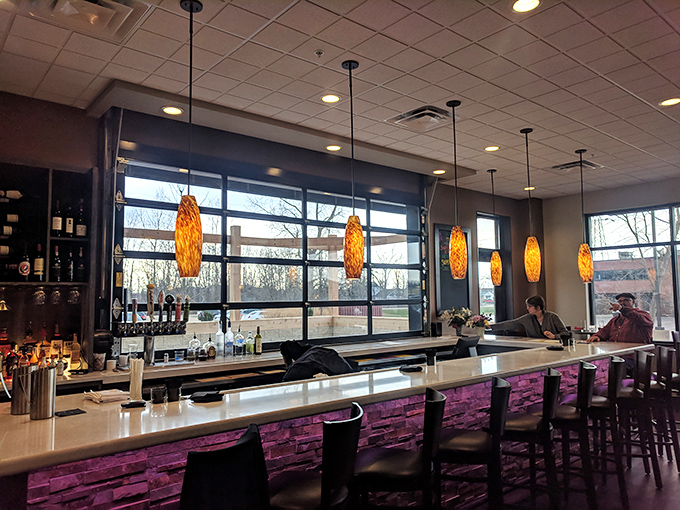 The bar area glows with amber pendant lights, creating the kind of ambiance where "just one drink" easily becomes "let's see the dessert menu."