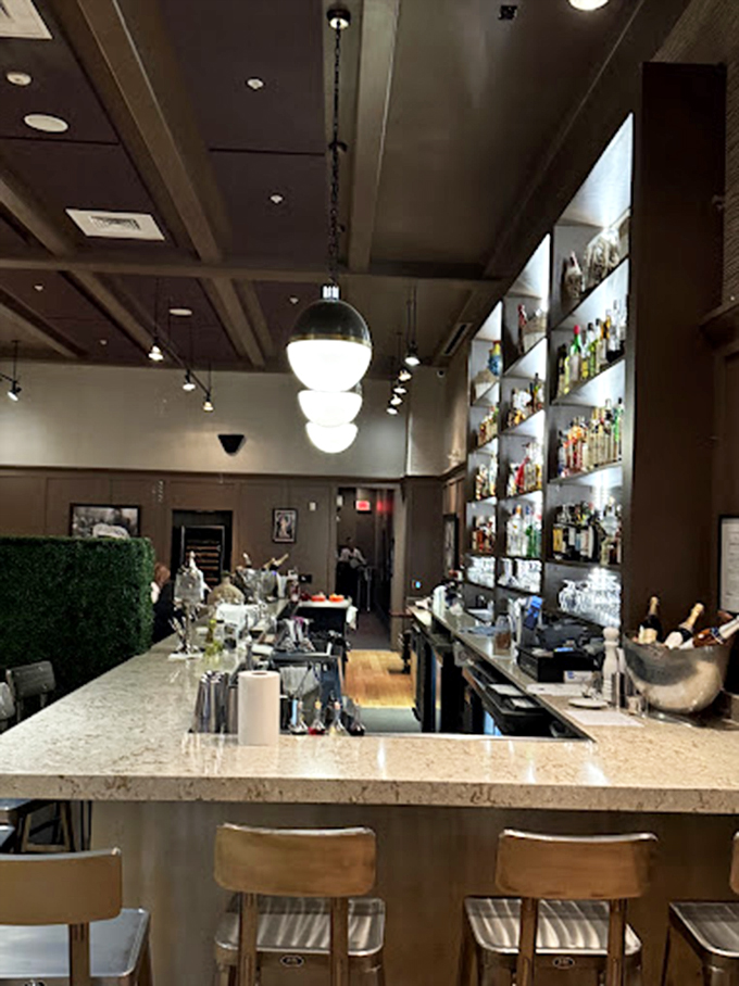 The bar area doesn't just serve drinks&mdash;it offers liquid companionship for your culinary journey through France. Those pendant lights add just the right ambiance.