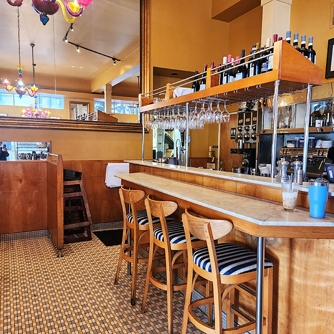 The bar at Rose's Cafe: where wine bottles stand at attention, ready for their moment to shine. Those colorful chandeliers add just the right touch of whimsy.