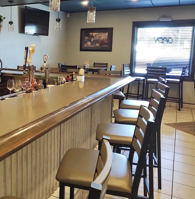 The bar seating area invites solo diners and couples to perch comfortably while watching the bartender's liquid choreography.