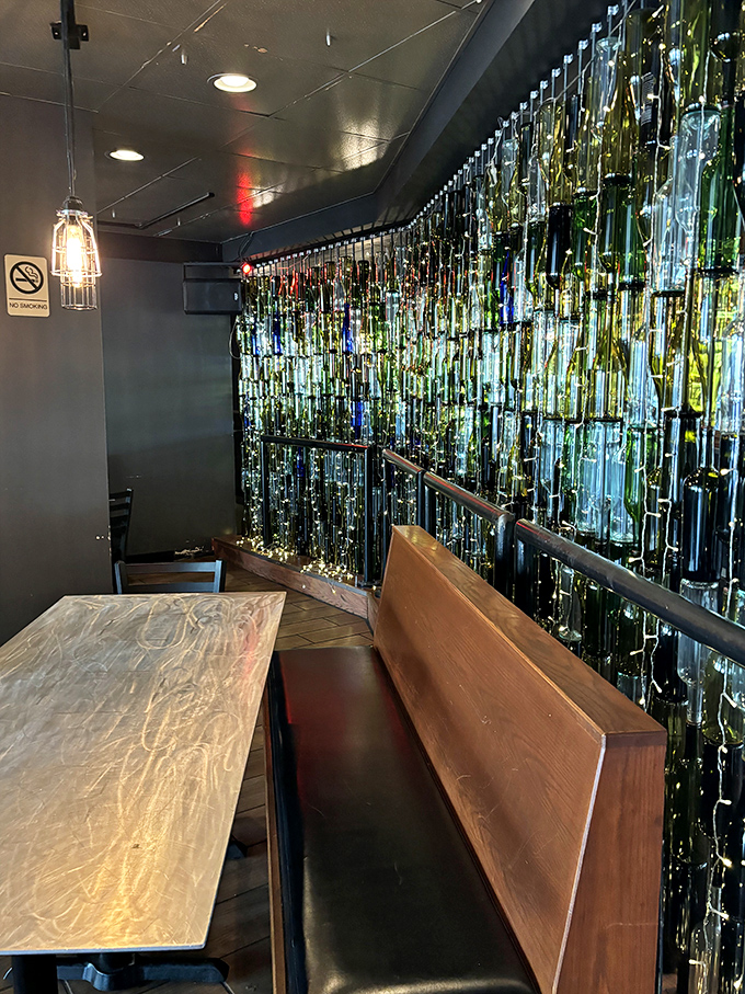 Booth seating backed by an illuminated bottle wall&mdash;dinner and a light show in one convenient package.