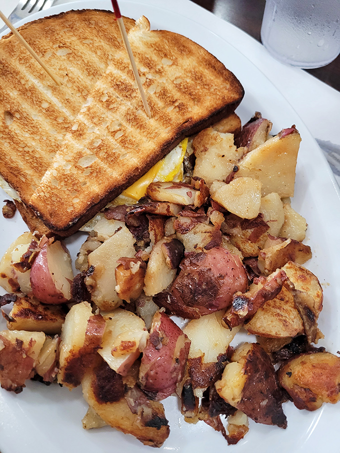 Toast with the perfect grill marks flanking home fries that look like they've been to potato finishing school. Breakfast architecture at its finest.