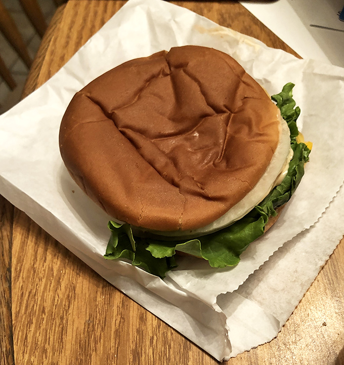 A classic burger sits wrapped and ready, promising that perfect balance of simplicity and satisfaction in every bite.