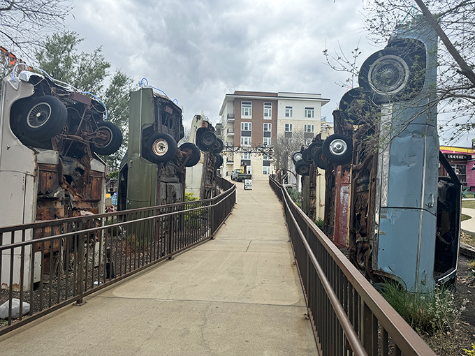 A walkway flanked by vertically mounted cars creates a surreal entrance experience worthy of this unconventional attraction.