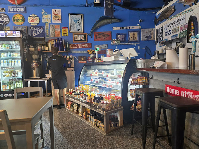 The market side reveals a nautical-themed wonderland where fish replicas watch over the day's fresh catch with approving glass eyes.