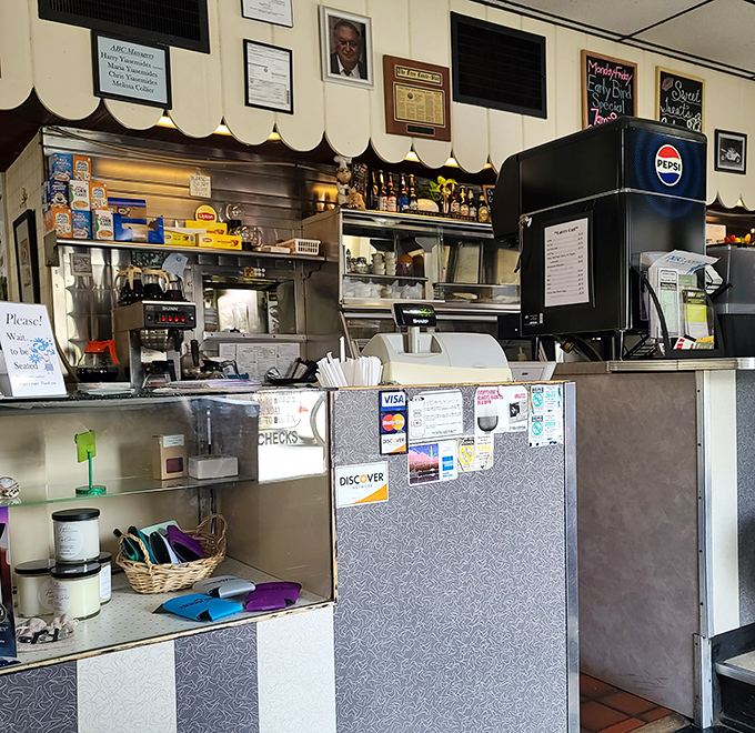 The cashier station—final stop on your journey to breakfast bliss. Those credit card logos promise you can pay with plastic, but the experience remains delightfully old-school.