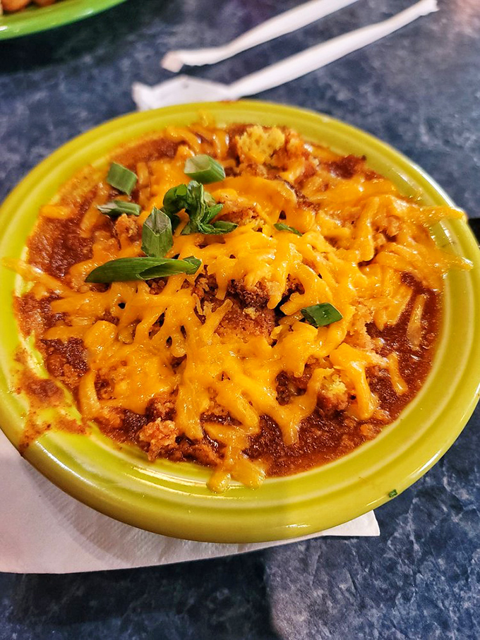 This bowl of chili topped with melted cheddar and green onions isn't just food &ndash; it's a warm, spicy hug that says "everything's going to be okay."