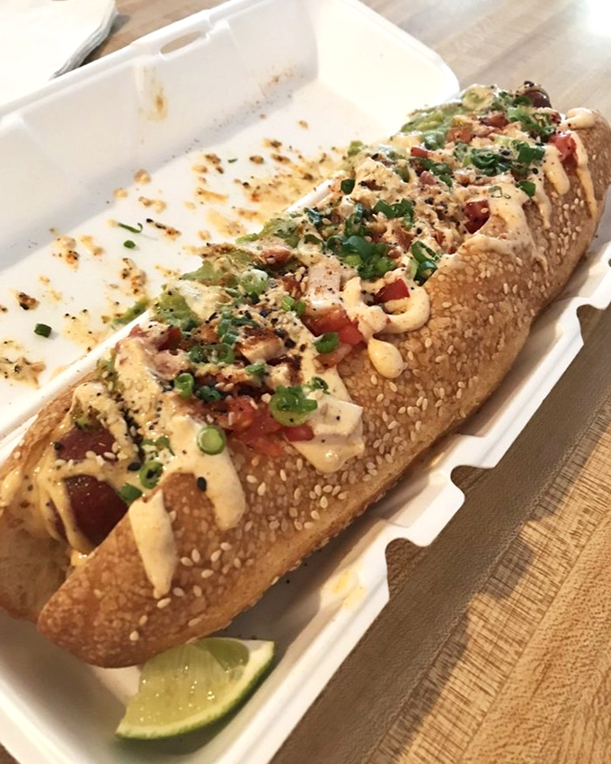 A sandwich that's dressed better than most people at a wedding, topped with fresh herbs and served with a lime wedge for that perfect finish.