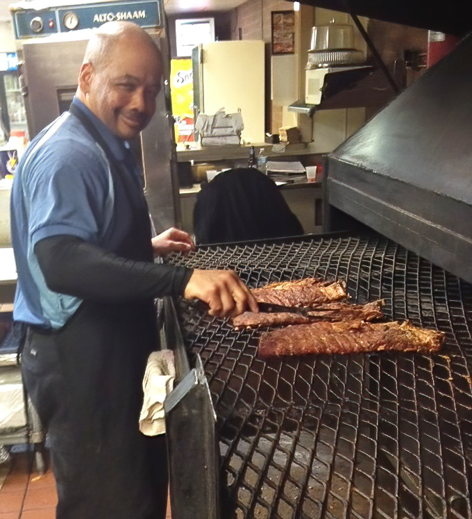 Where the magic happens - skilled hands transforming humble cuts into transcendent barbecue through smoke, time, and expertise.