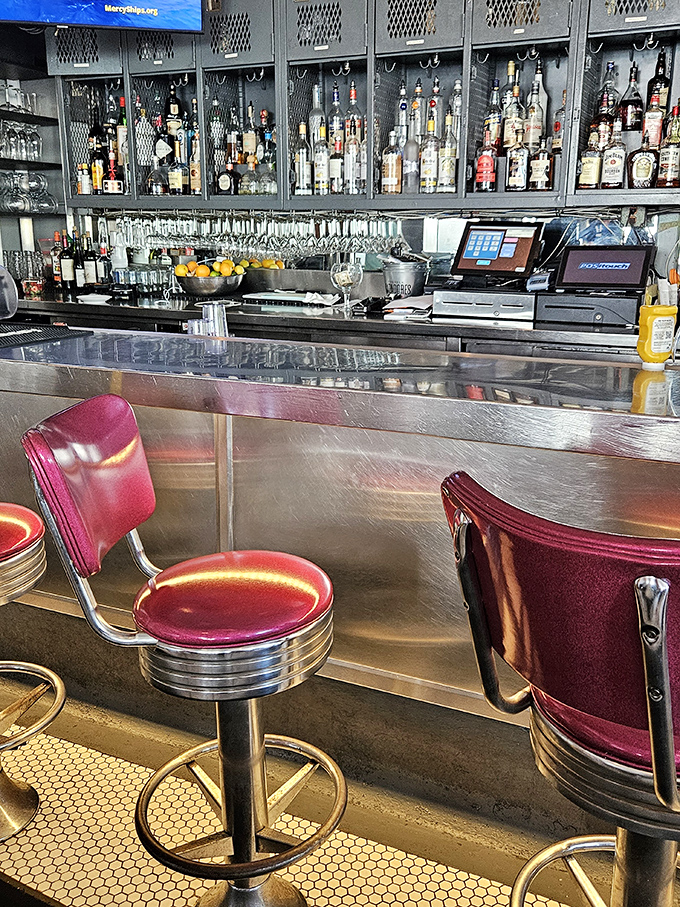The bar's industrial-chic aesthetic pairs burgundy leather with metal caging, creating a space where Miami sophistication meets practical comfort. Cocktails with character await.