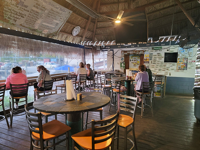 The covered patio offers shelter without separation from nature. Ceiling fans stir the salt air while diners savor treasures harvested from the waters beyond.