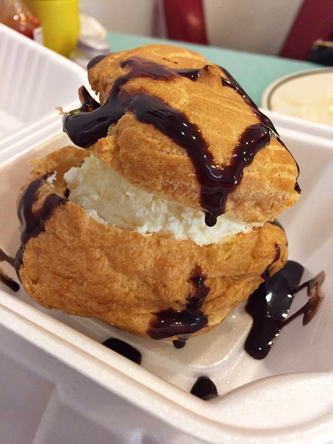 This cream puff isn't just dessert&mdash;it's architecture. A delicate pastry structure supporting a cloud of cream, drizzled with chocolate for good measure.