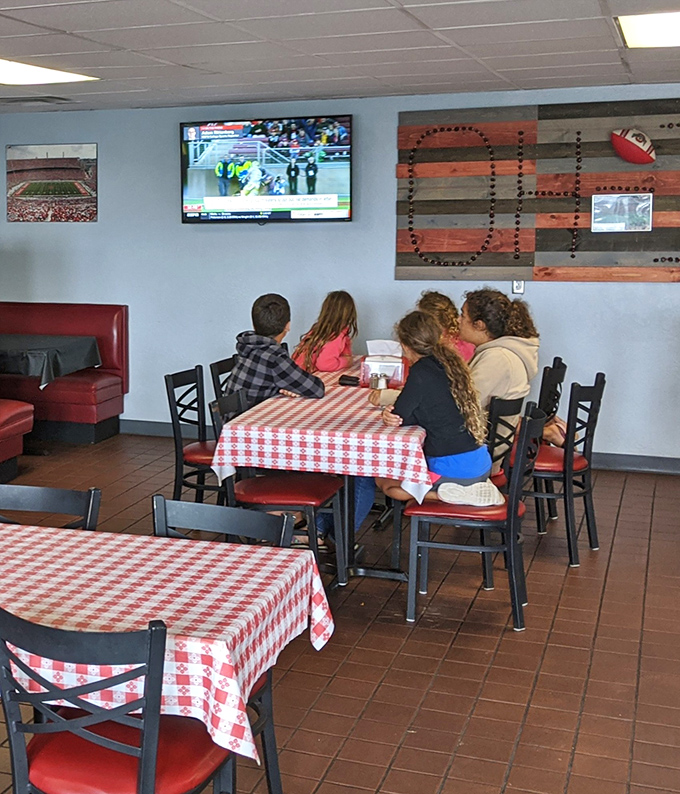 Families gathering around checkered tablecloths, creating memories over comfort food. The real entertainment isn't on that TV—it's happening right at the table.