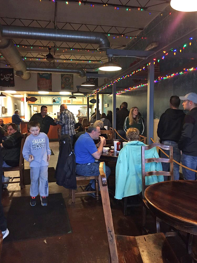 A bustling dining room where strangers become temporary family, united by the universal language of "pass the tartar sauce, please."