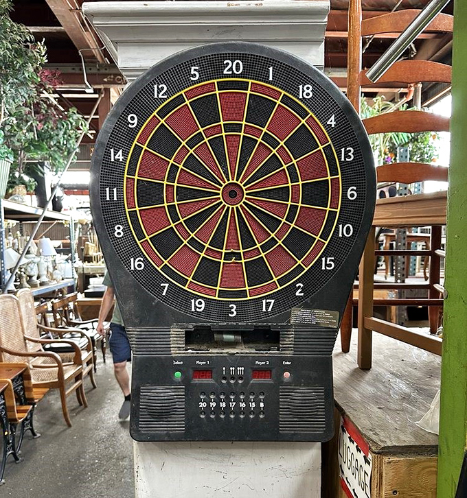 An electronic dartboard stands sentinel among dining chairs, proof that at Urban Ore, entertainment and furniture mingle like guests at an eclectic party. 